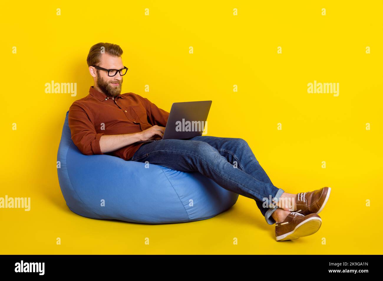 Full length portrait of handsome smart guy sit cozy bag use netbook ...