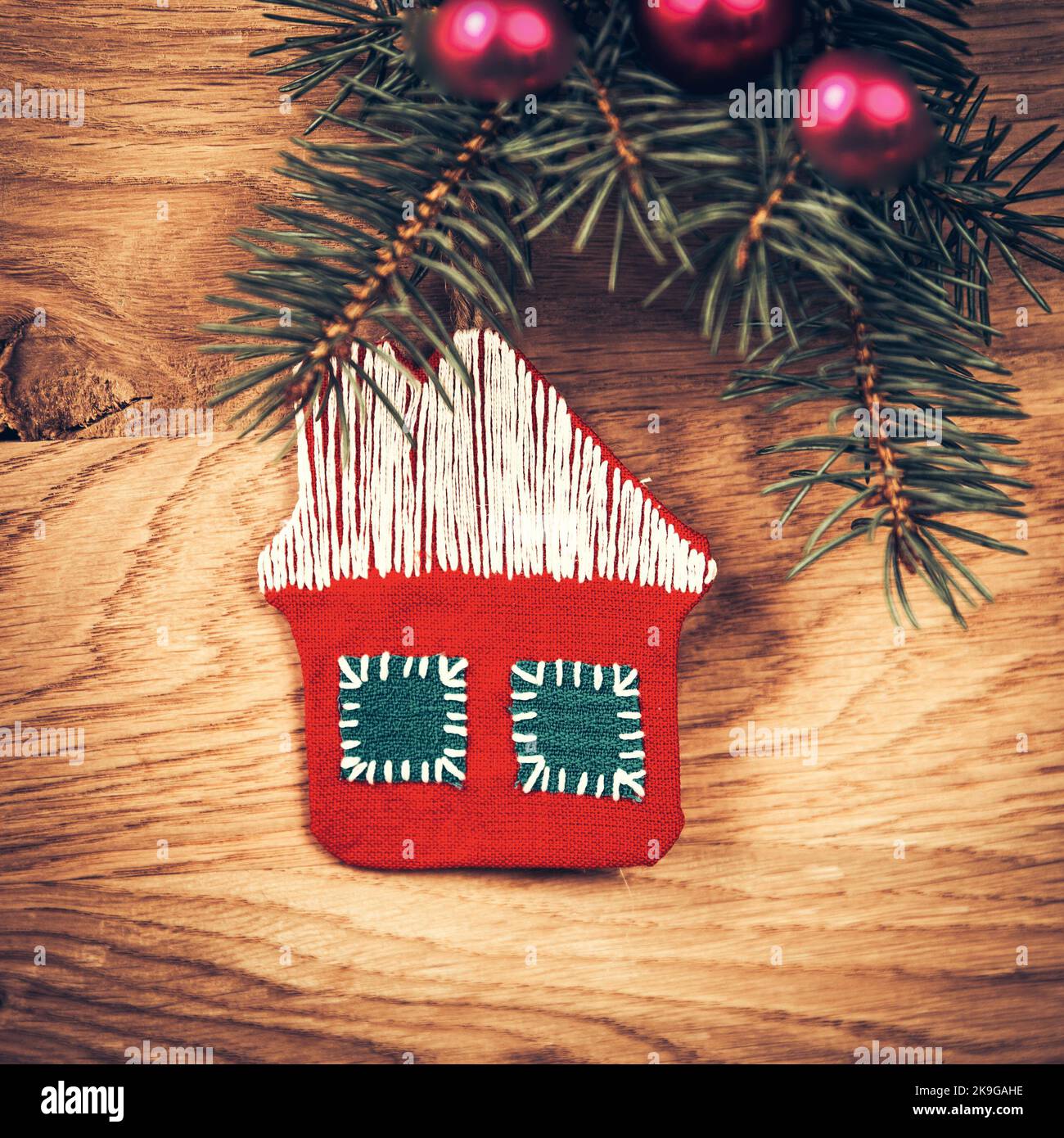 Christmas house with fir paws on wooden background Stock Photo - Alamy