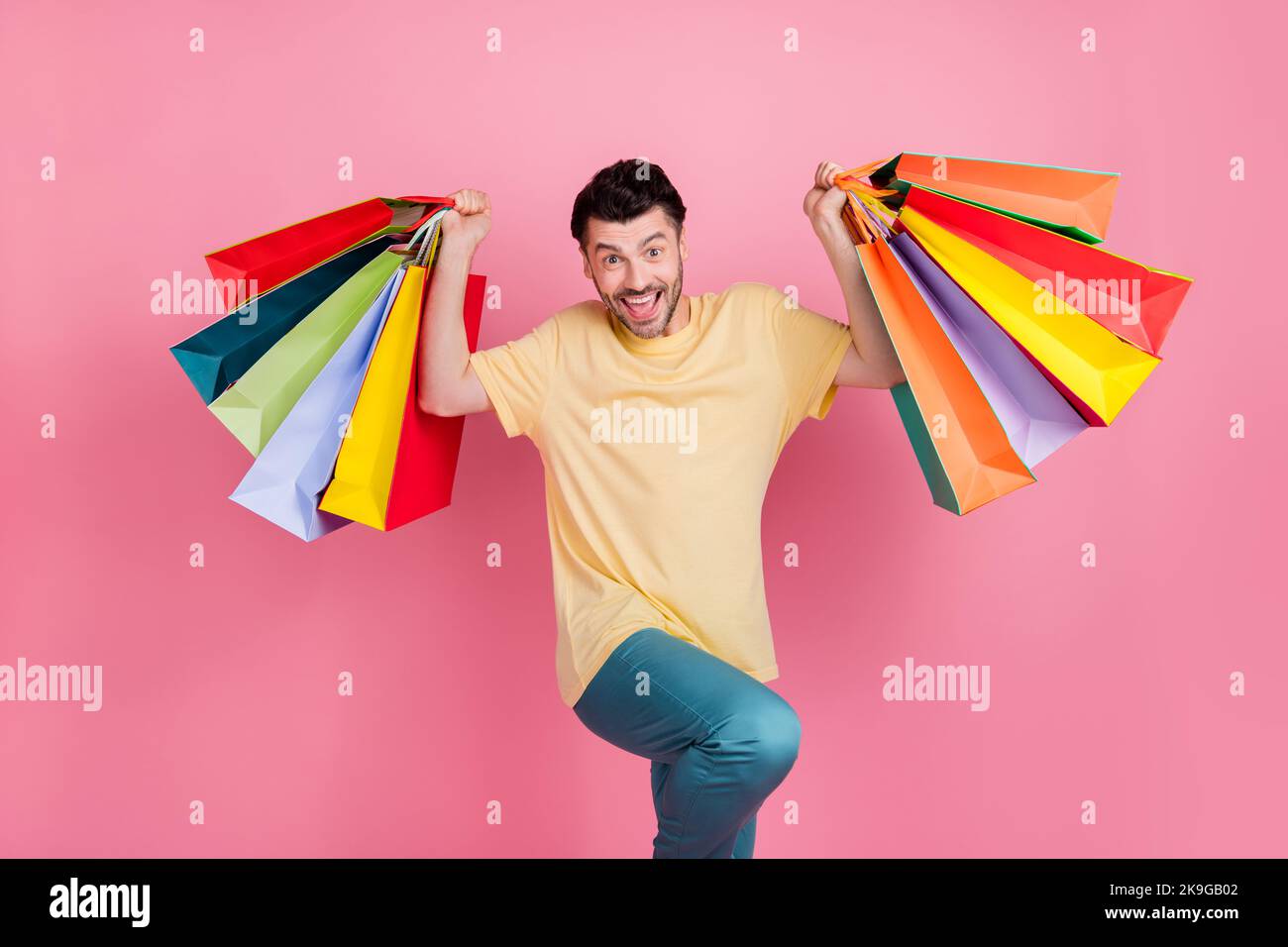 Photo of positive good mood man dressed yellow clothes raise hand packs ...