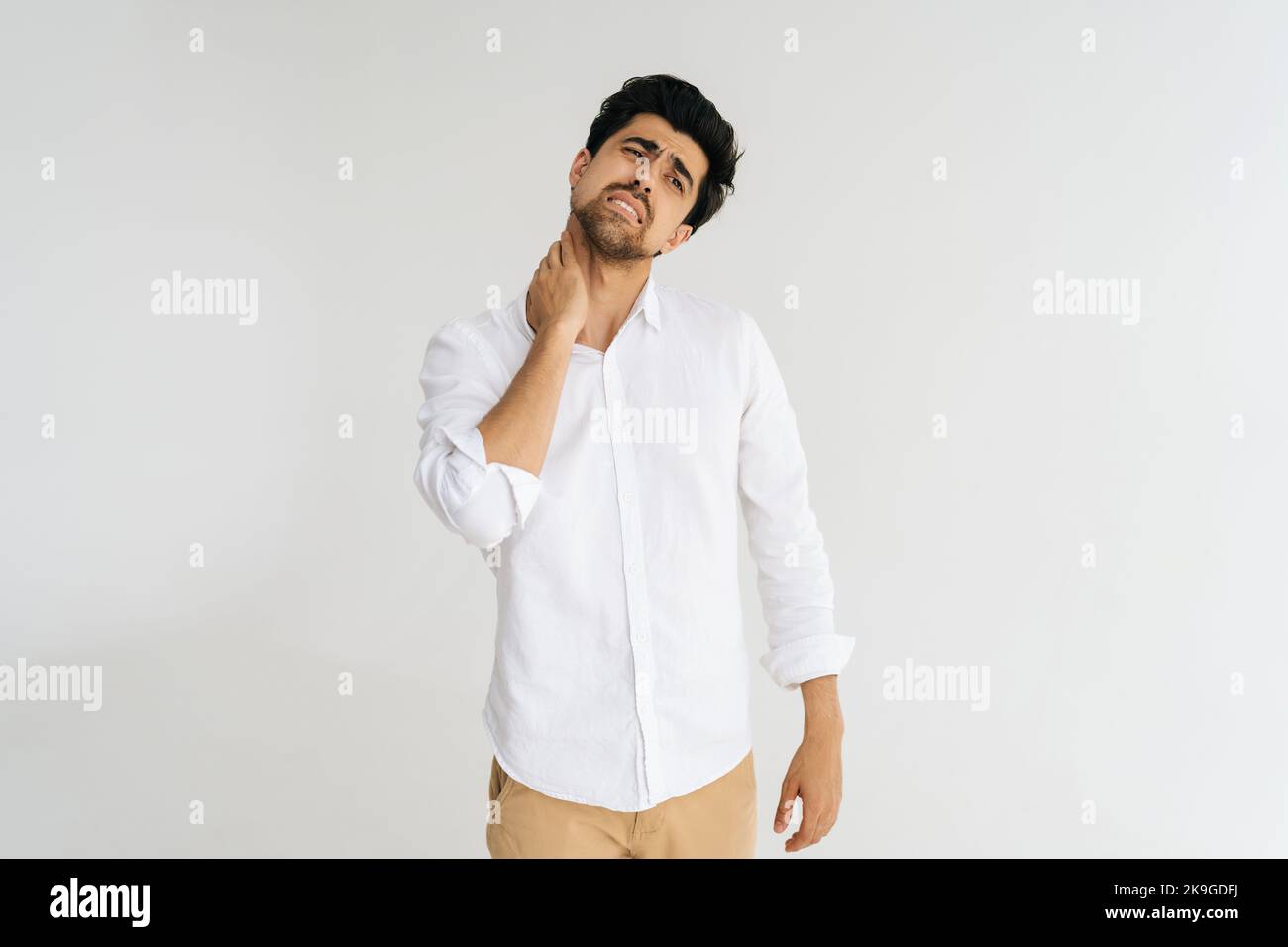 Studio portrait of suffering young man feeling physical discomfort ...