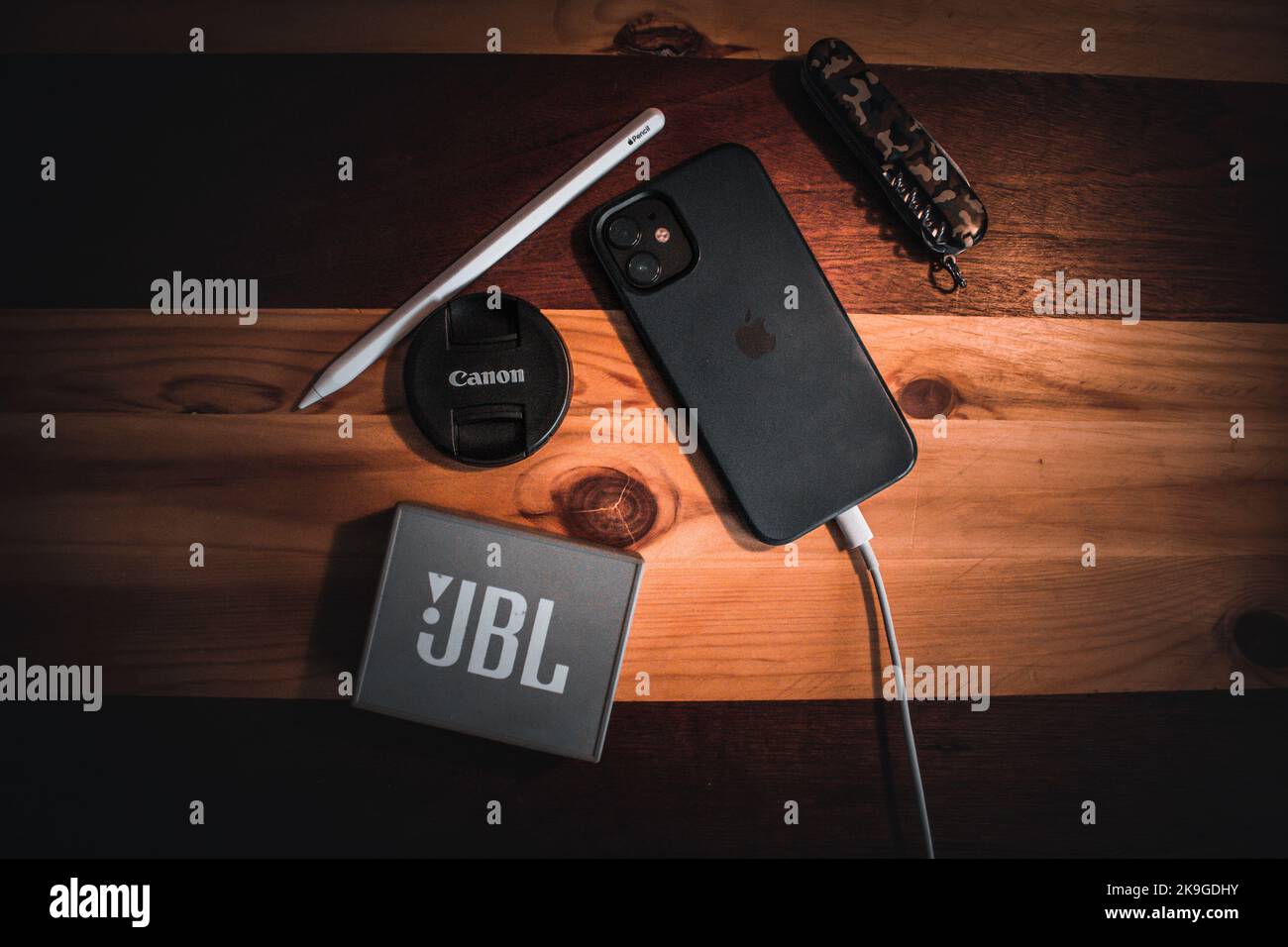 A top view of an iPhone next to a JBL speaker, Apple pencil, Canon ...