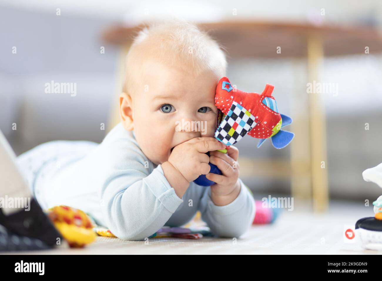 Cute baby boy playing with hanging toys arch on mat at home Baby ...