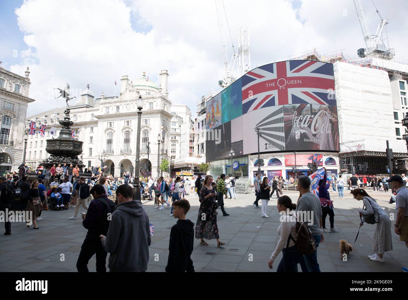 People walk past a Union flag with a logo on an electric board in ...