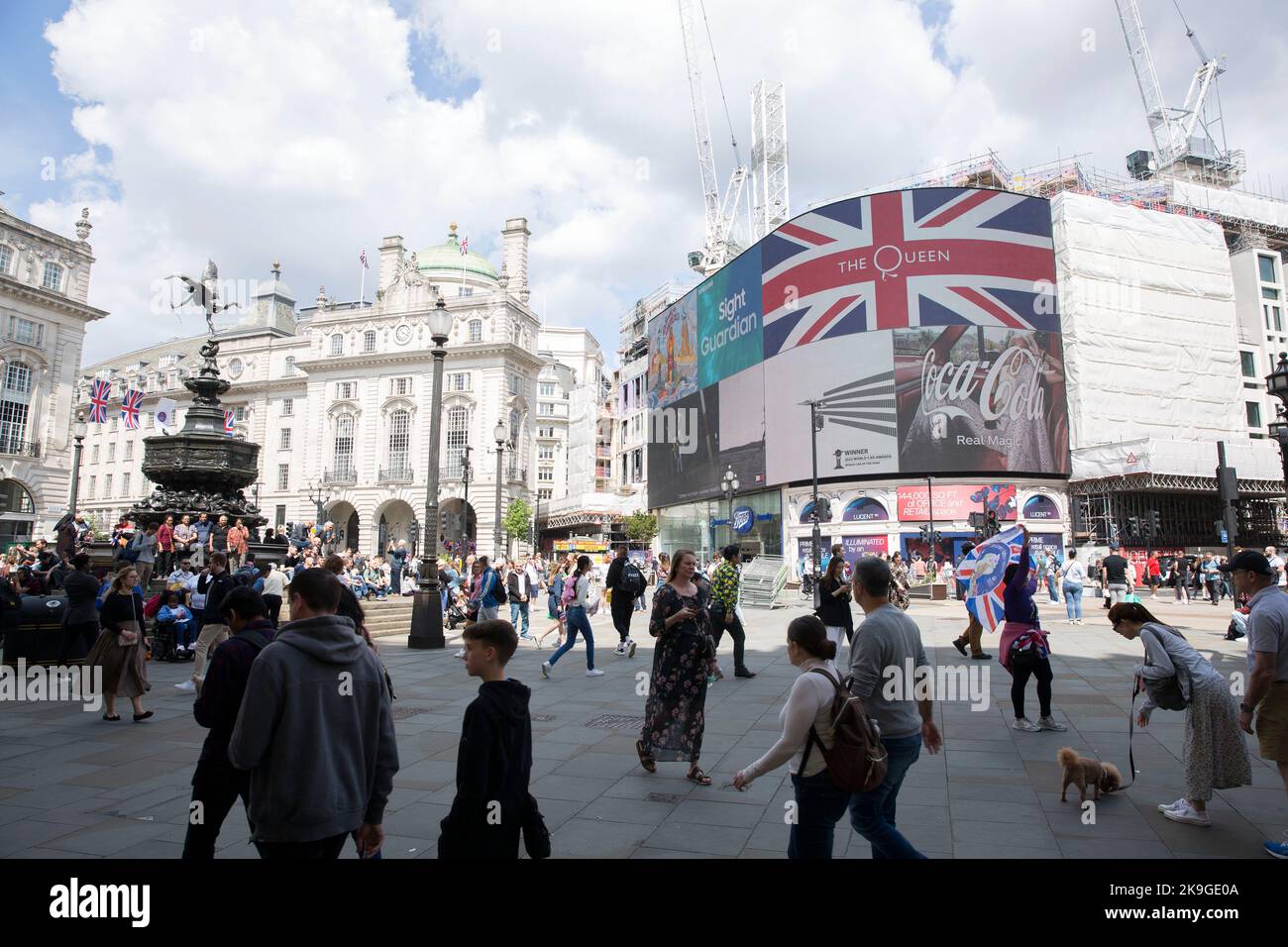 People walk past a Union flag with a logo on an electric board in ...
