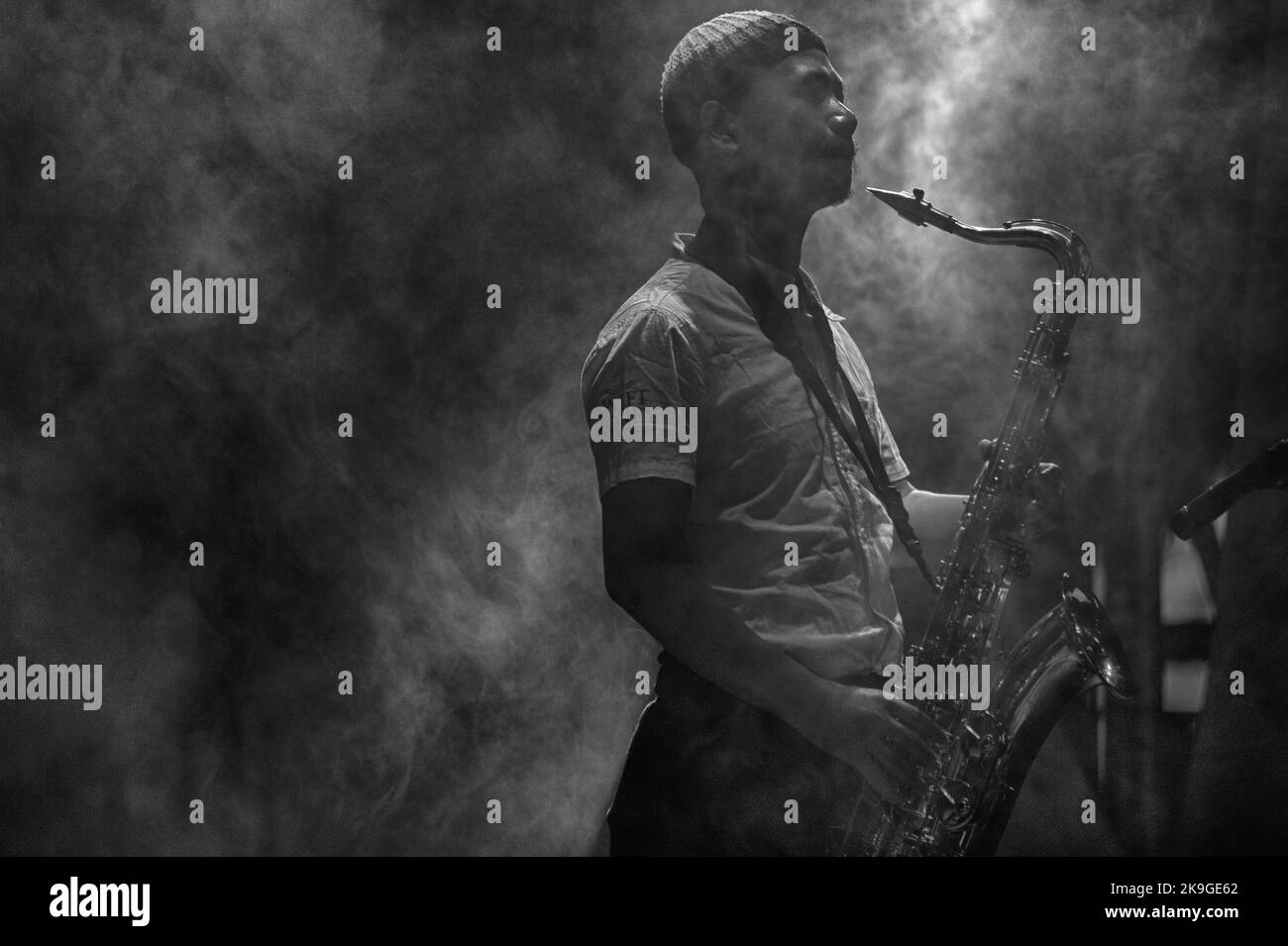A black and white shot of a guy playing the saxophone on a stage ...