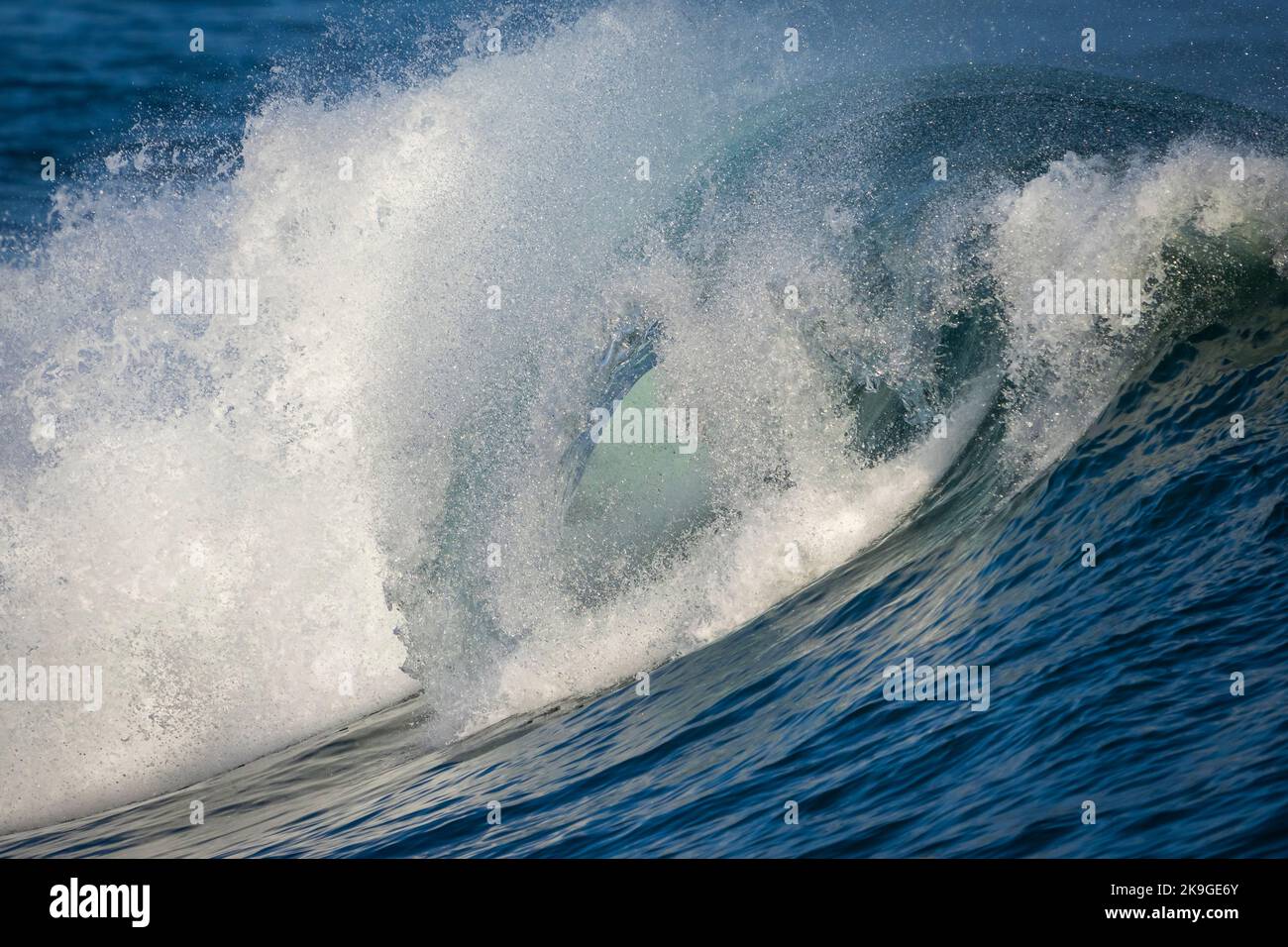 Blue Atlantic Ocean wave breaking, spray flying on the Hermanus shore ...