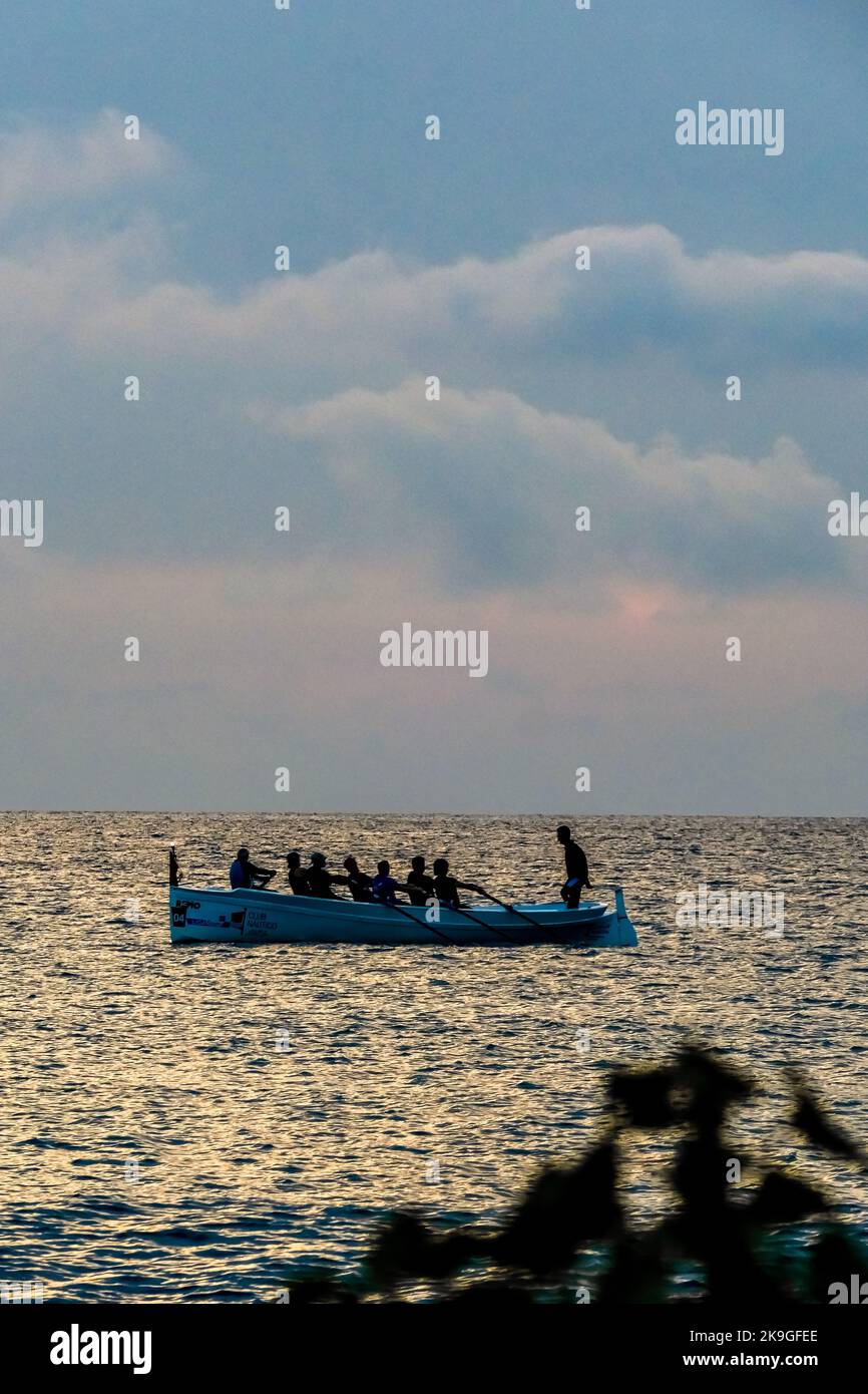 A vertical shot of the boat with rowers under the blue sky Stock Photo ...