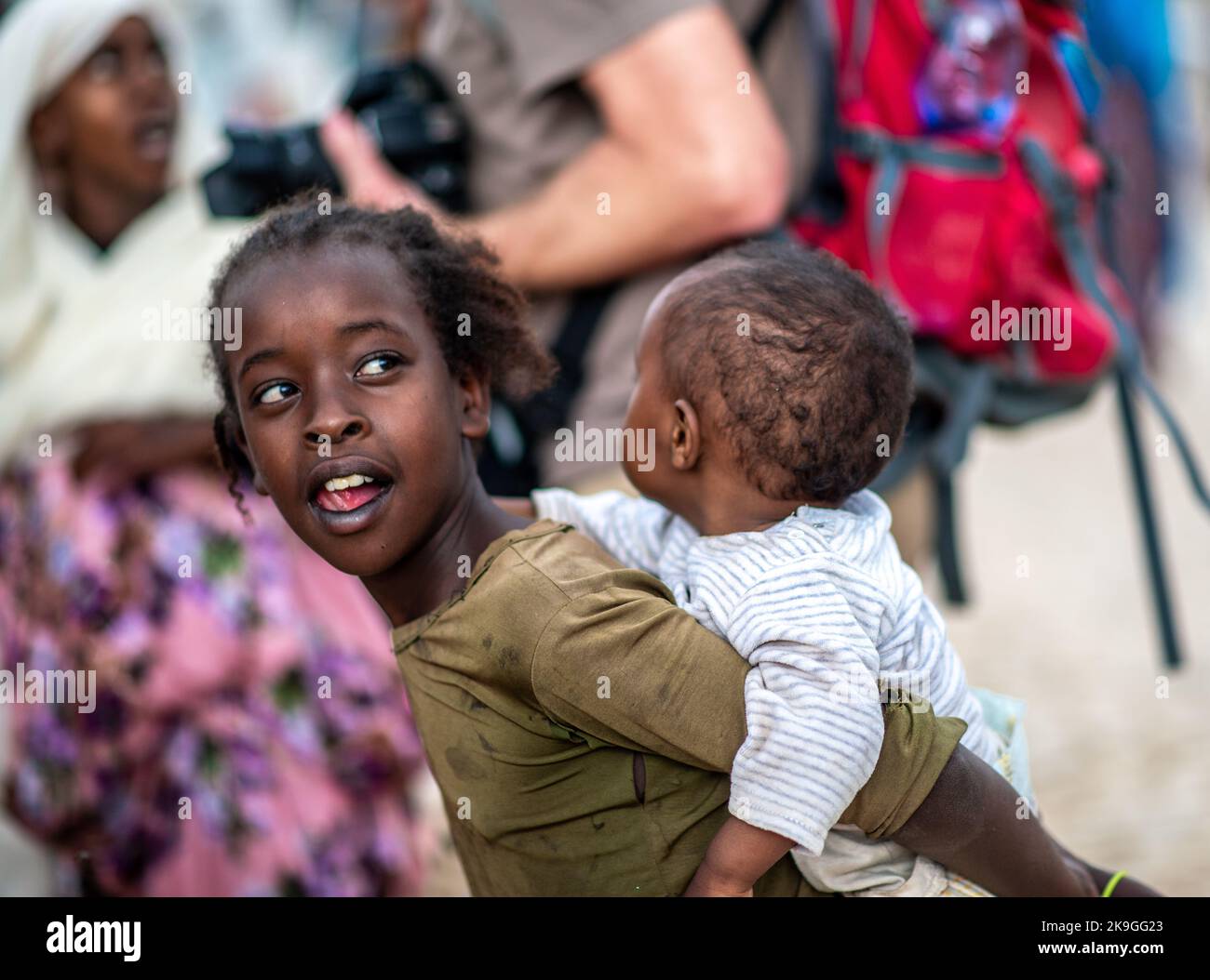 A girl carrying a small child on her back in the City of Harar Ethiopia ...