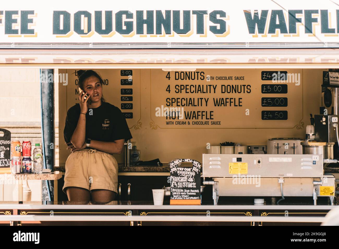 A street Food worker in stall. Dougnuts & Waffles Stock Photo - Alamy