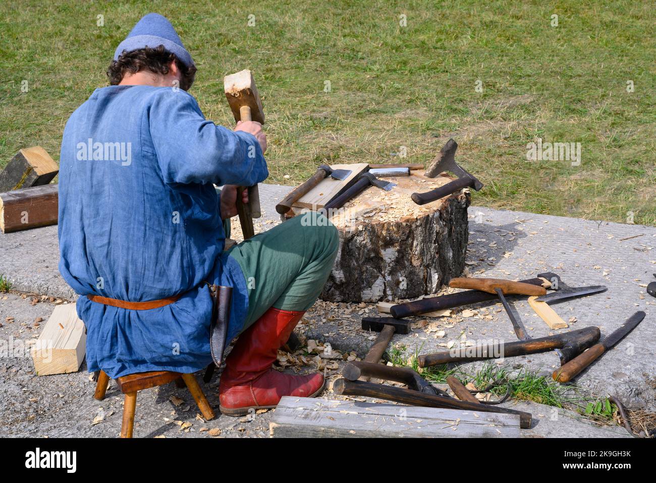 A man is working on a wooden product with antique tools, as it was 500 ...