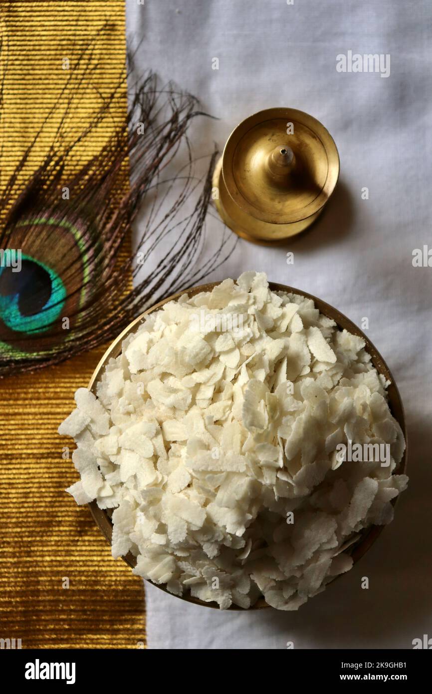 Close-up of raw poha/beaten rice/flattened rice/Brass oil lamp/Peacock ...