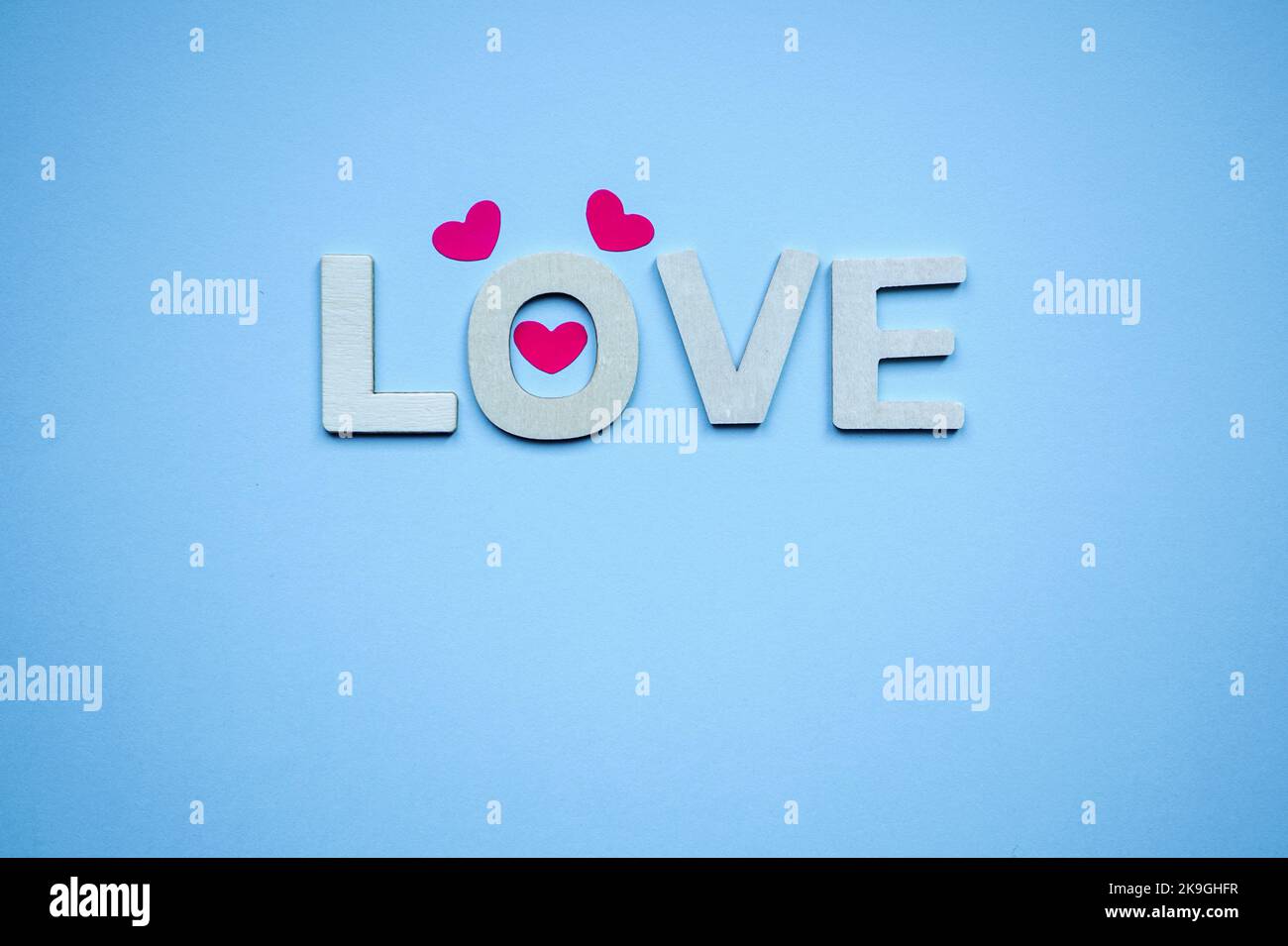love wooden letters and heart shapes on the blue background for ...