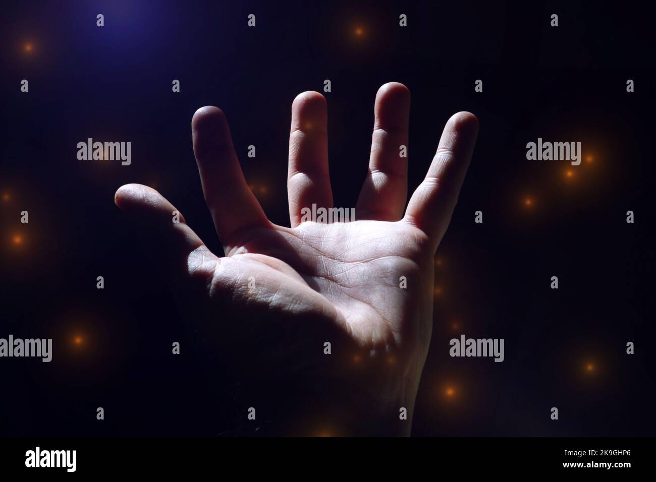 man hand up gesturing in the shadows, dark background Stock Photo - Alamy