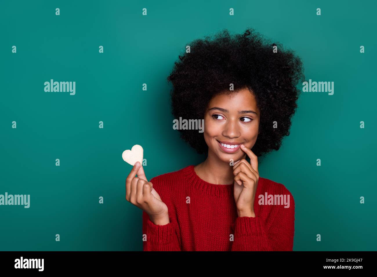 Photo of lovely schoolgirl hold look heart shape cookie bite finger ...