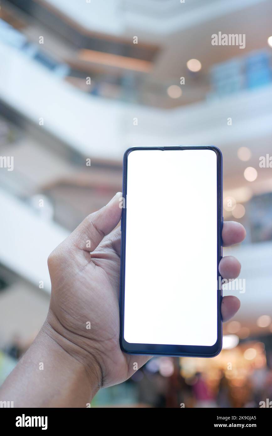 young man hand using smart phone with green screen against city ...