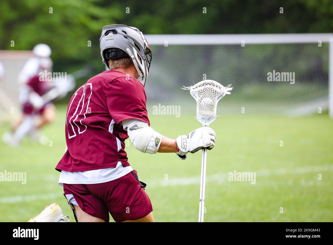 A closeup of a lacrosse player running in a sports field Stock Photo ...