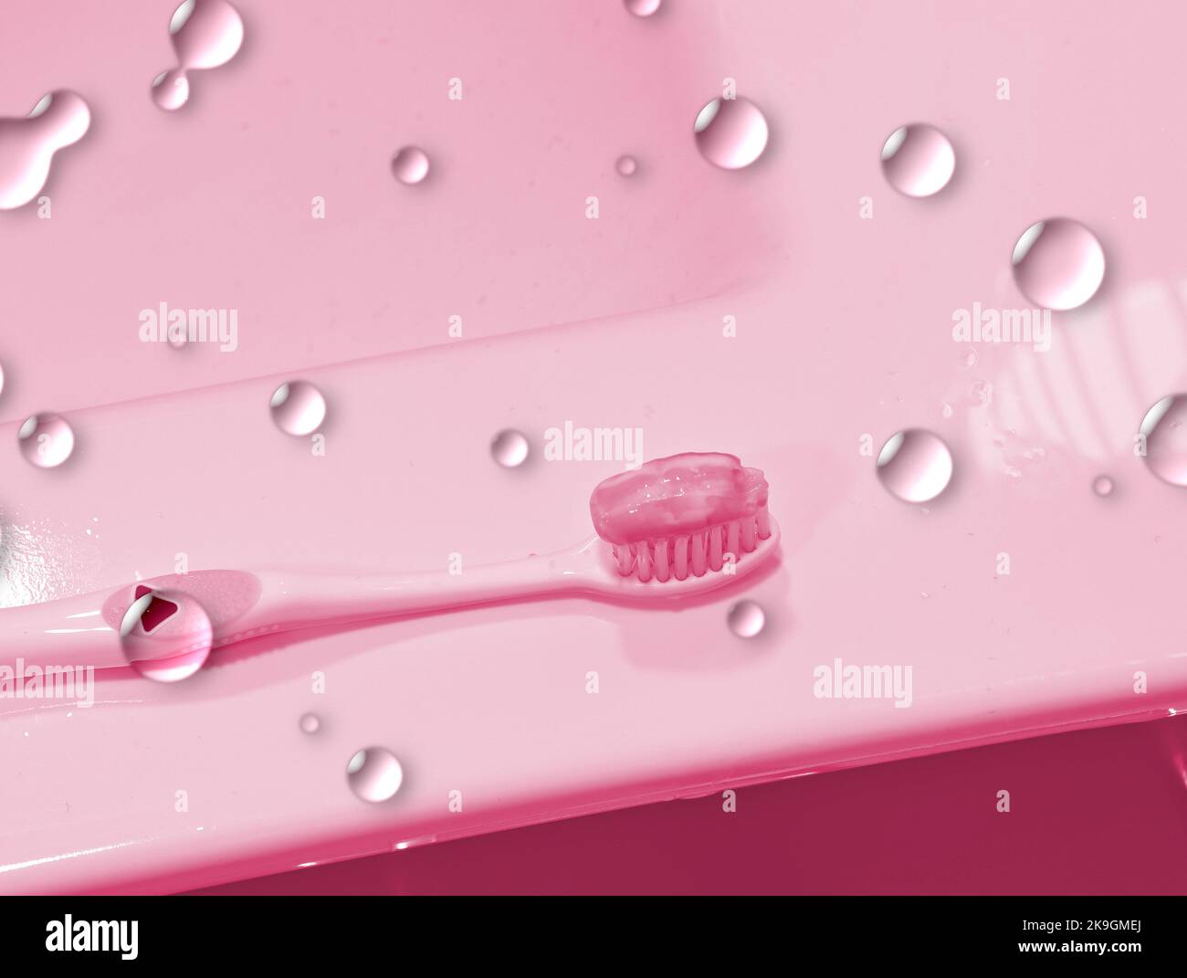 toothbrush with toothpaste in the bathroom in pink color with drops of ...