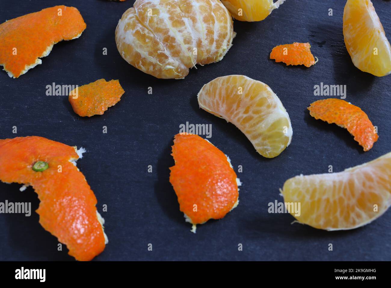 citrus mandarin fruits with mandarin peel on black plate Stock Photo ...