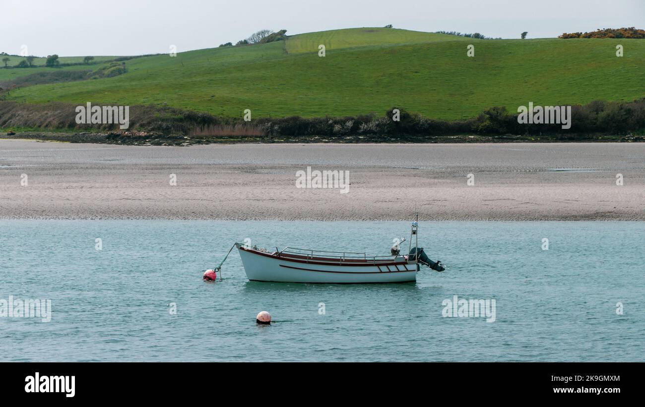A small motor boat moored in shallow water. Sandy beach. Seascape ...