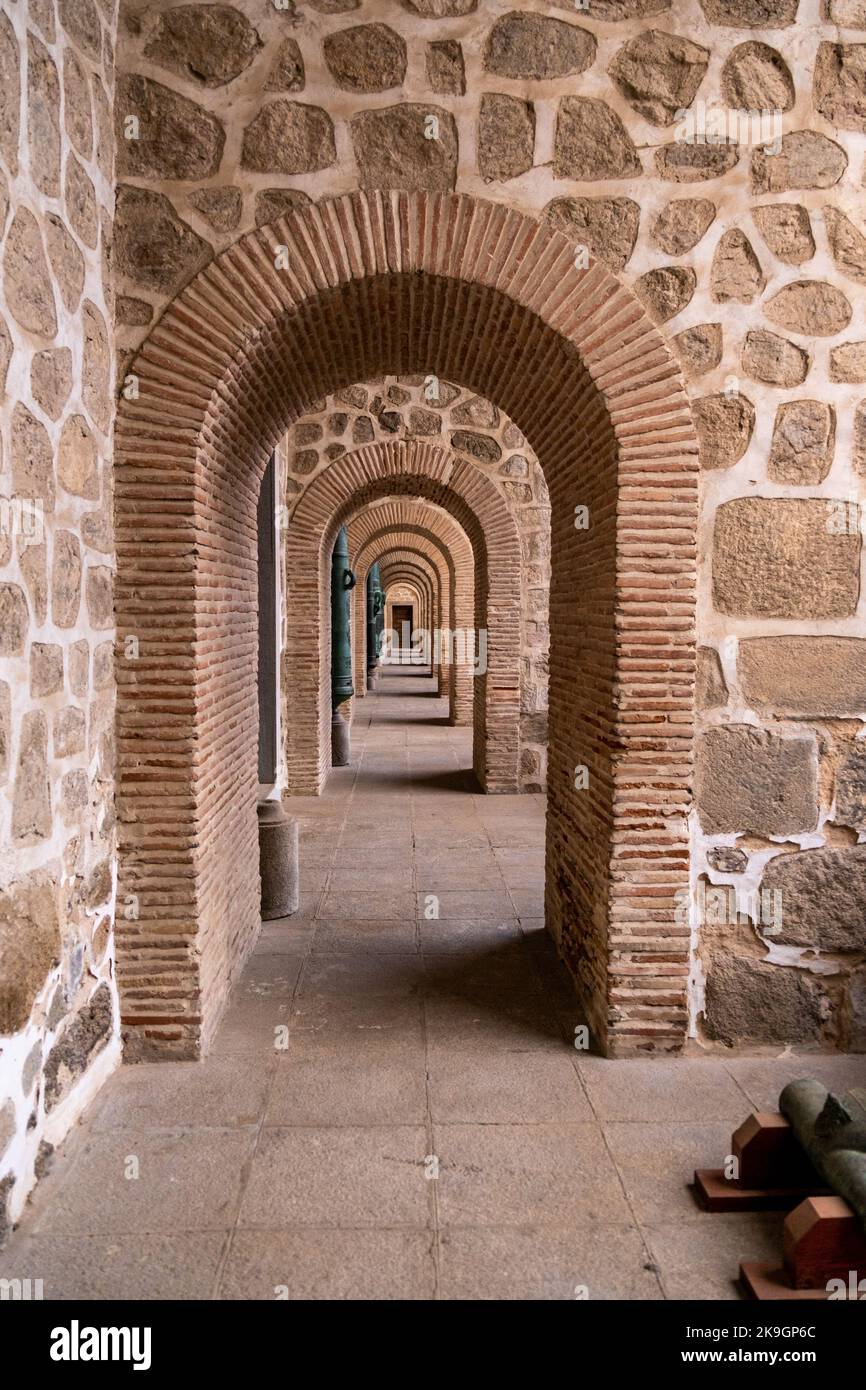 A vertical of an external hallway with stones supported by columns and ...
