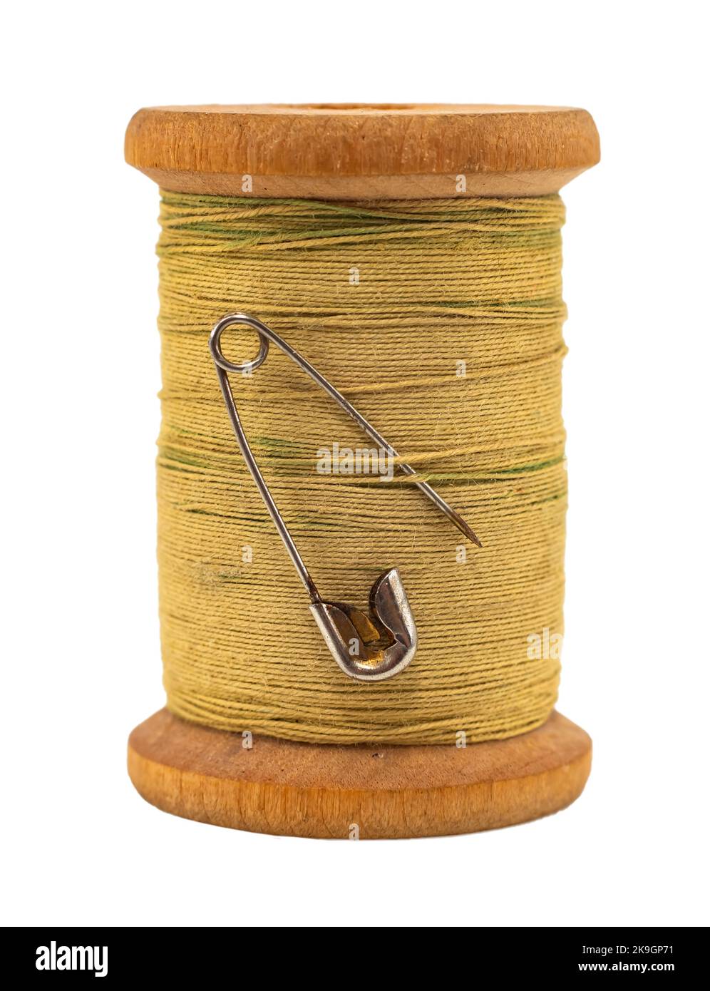 An old wooden spool of thread and a needle on a white background close ...