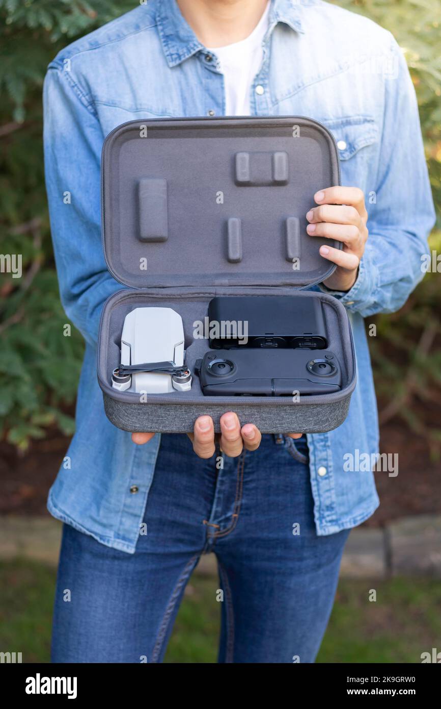 Frontal portrait of a man exposing his new Folding Drone Stored in his ...
