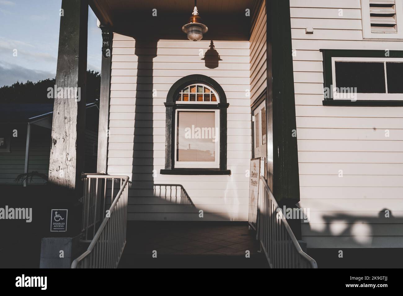 small glass window by the entrance stairs of a cute little old wooden ...