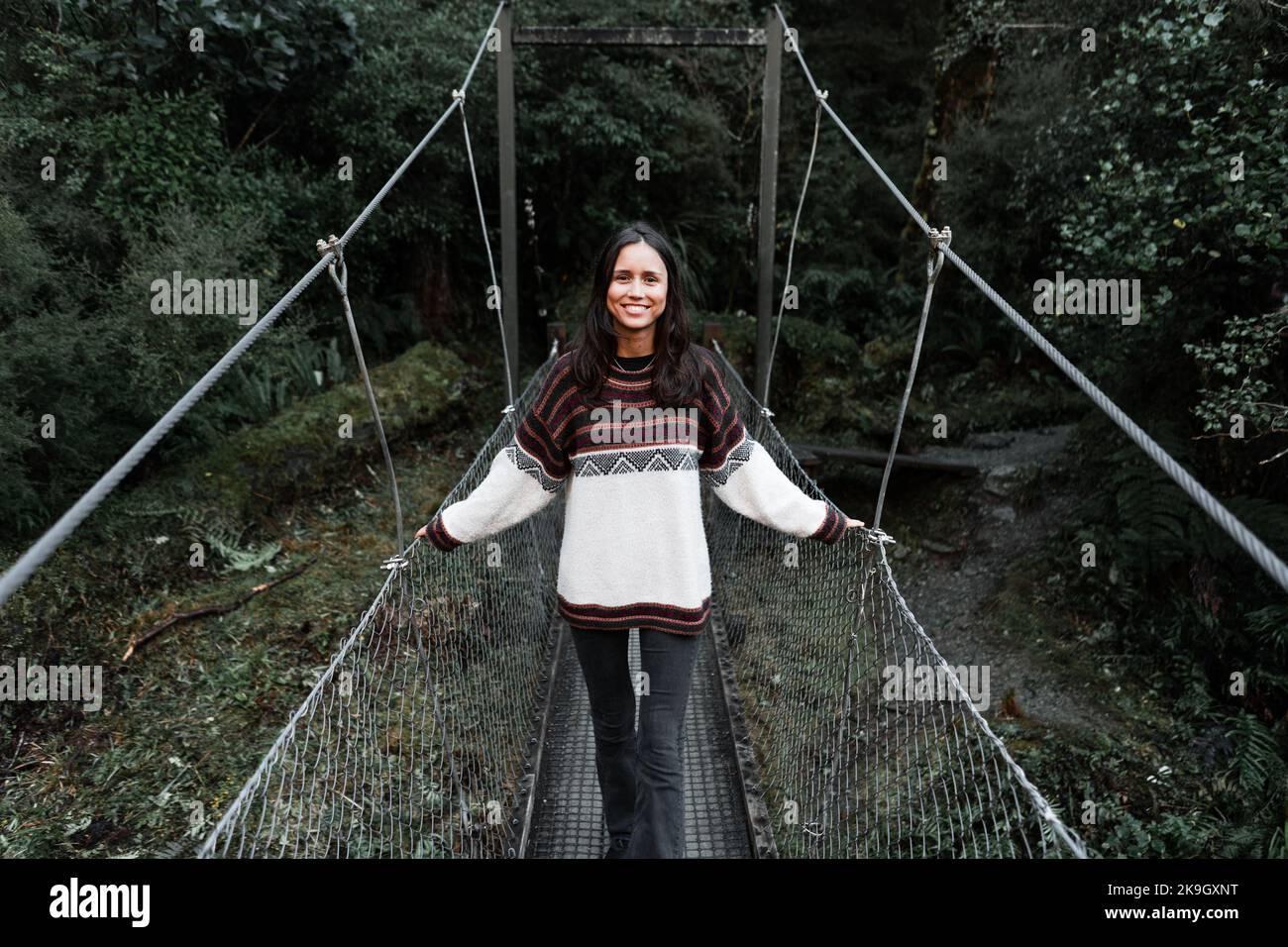 young caucasian woman smiling at camera in loose red and white wool ...