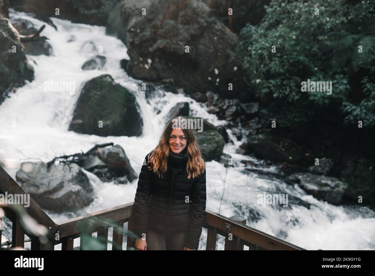 blond caucasian young woman smiling at camera with black jacket gray ...