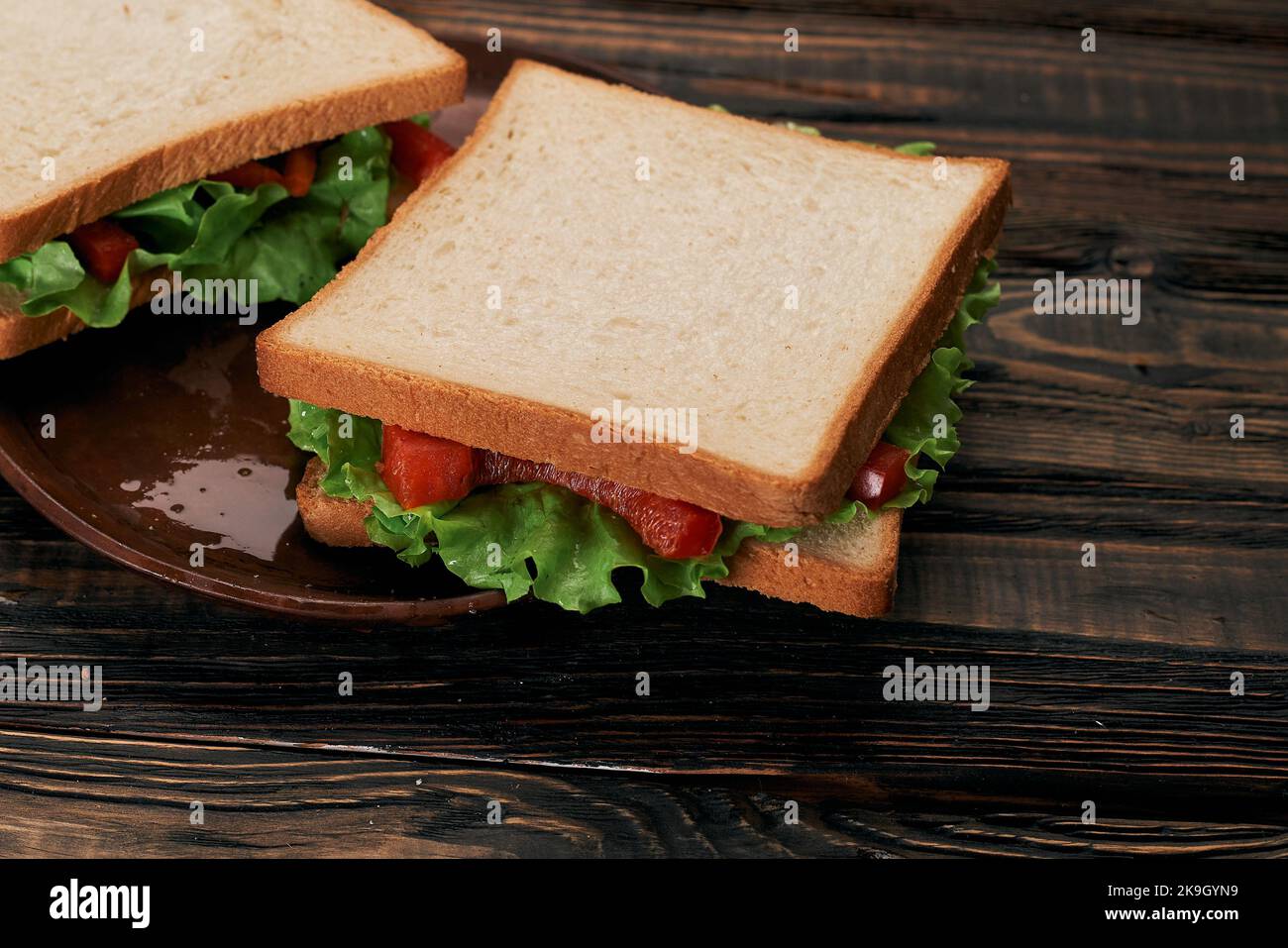 two tomato sandwiches on a wooden board Stock Photo - Alamy