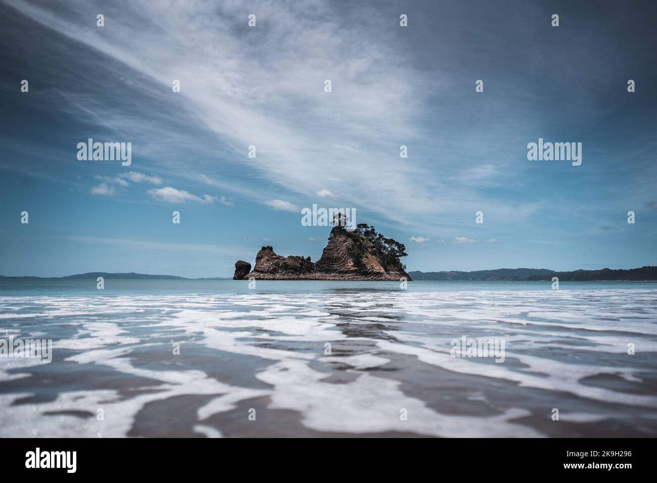 uninhabited island and mountains above the sea foam in new chums Stock ...