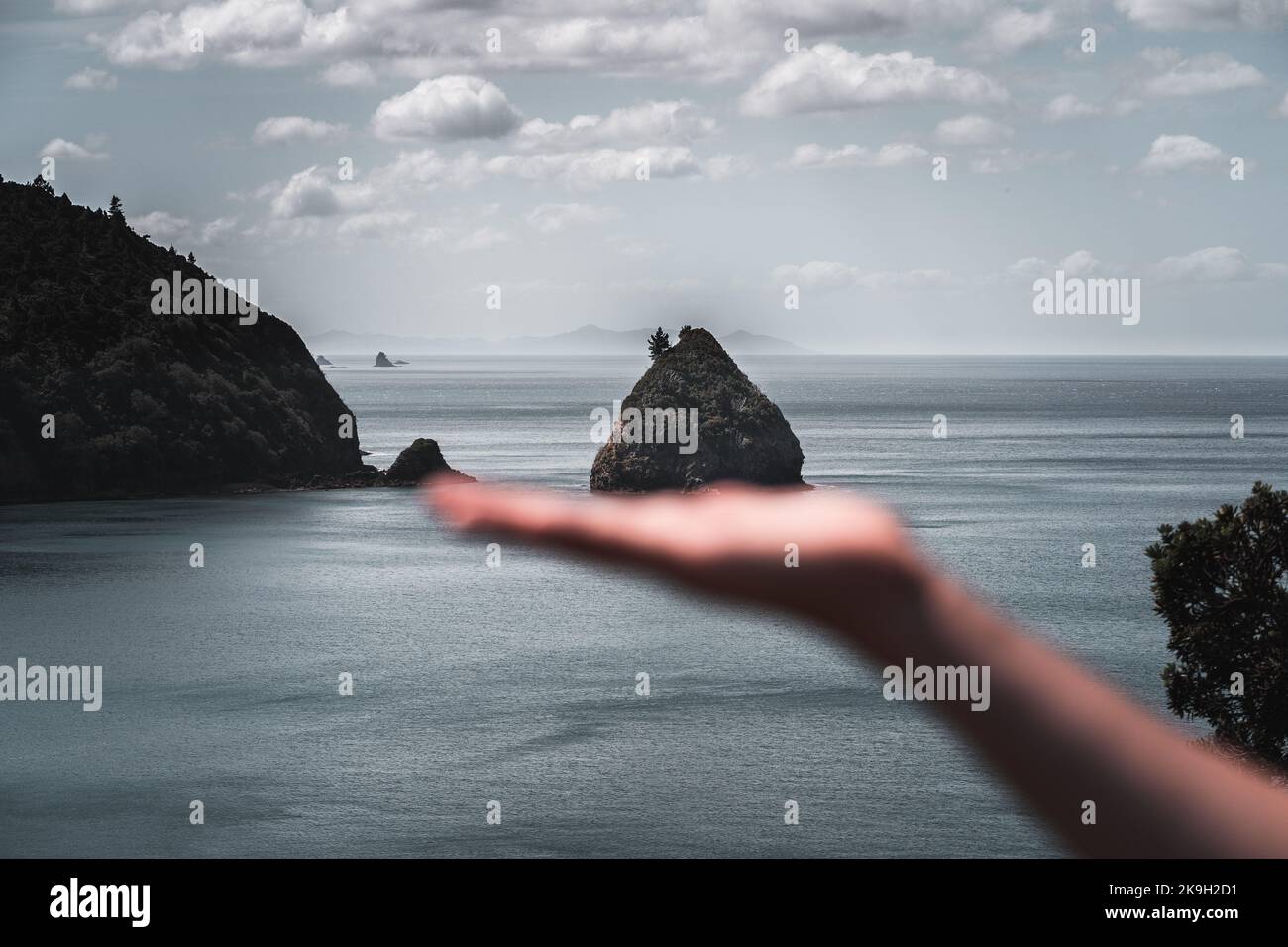 small island held by a human hand in new chums Stock Photo - Alamy