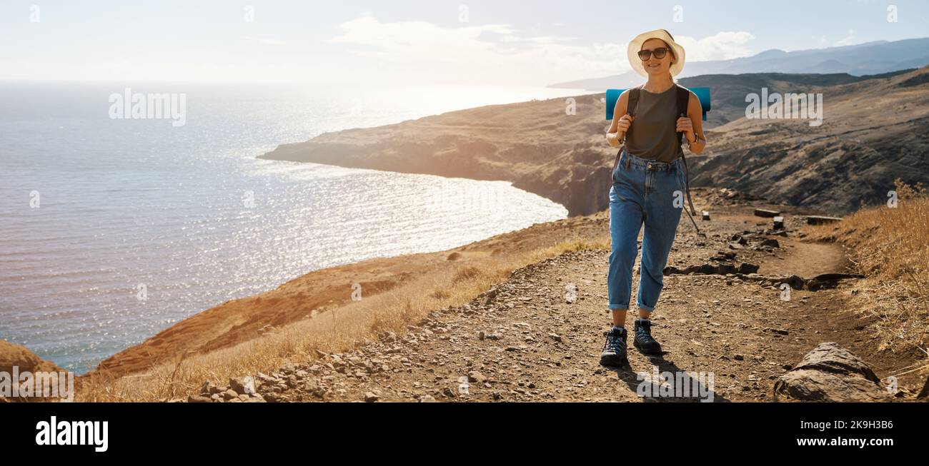 pilgrim on the pilgrimage. young smiling woman walking ocean coastal ...