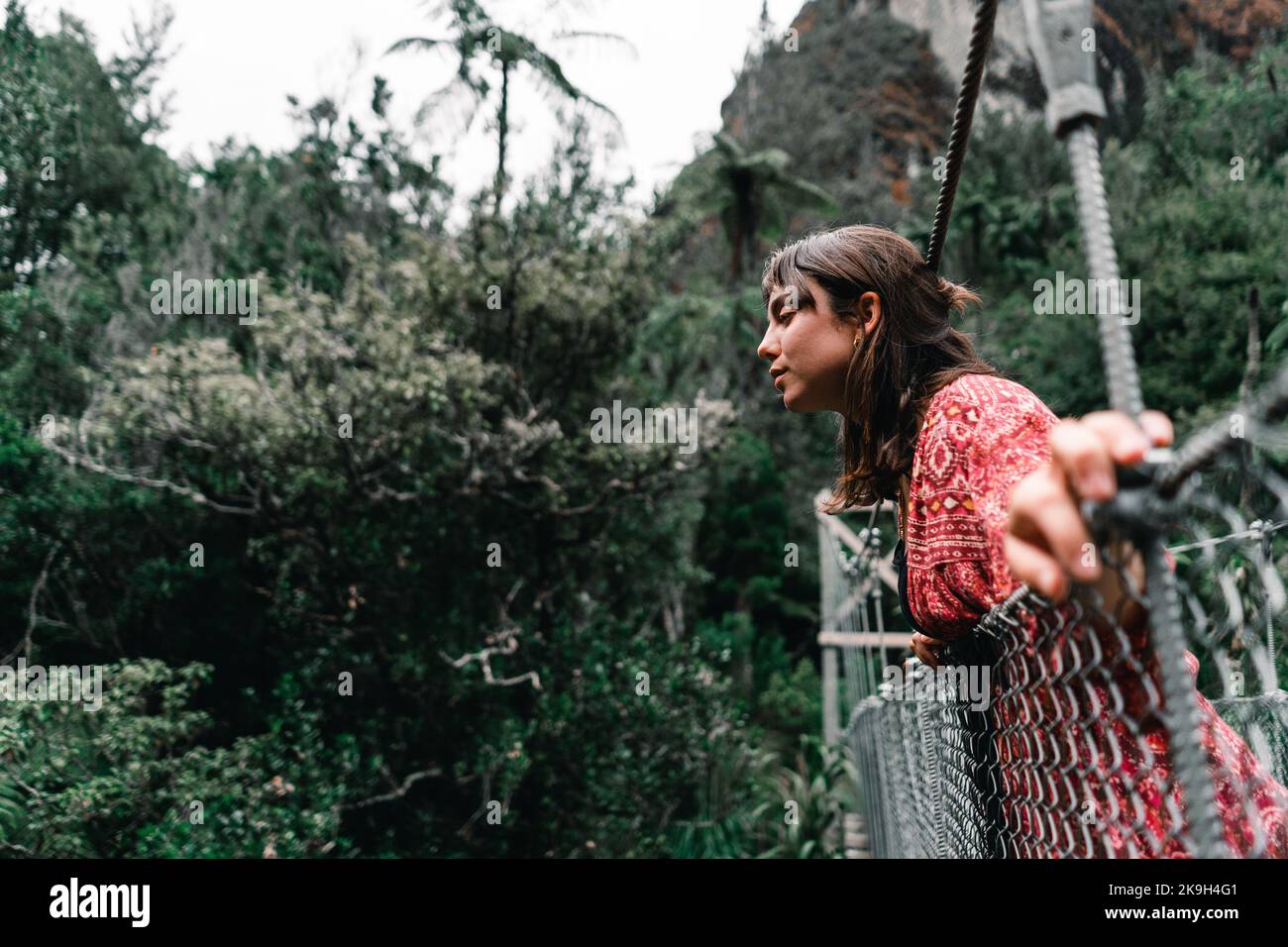 disheveled caucasian young woman leaning on the metal railing of the ...