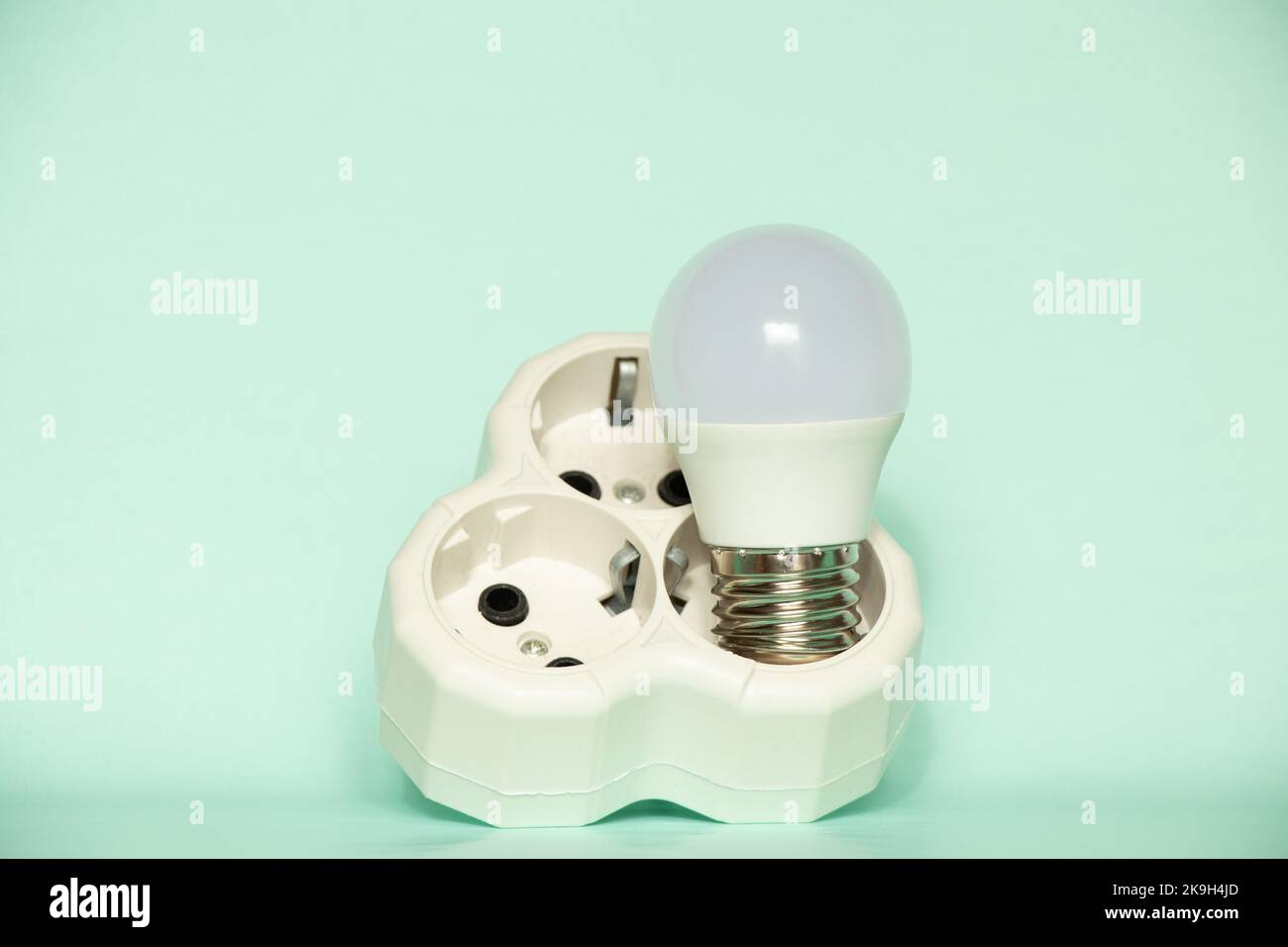 The Led Light Bulb Lies In A Triple Socket On A Blue Background Saves