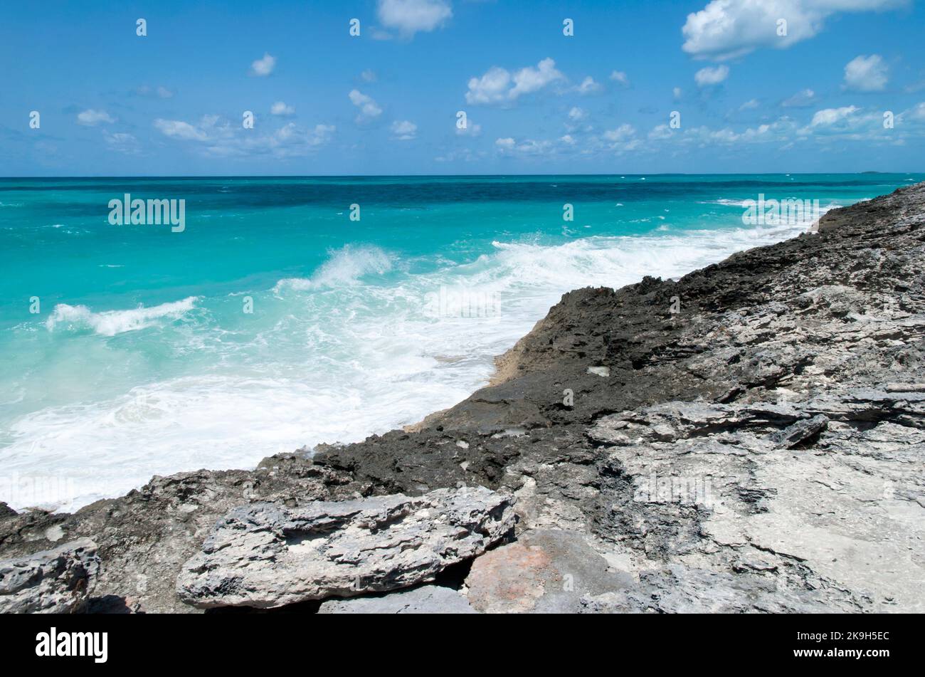 The turquoise color Caribbean Sea washing rocky shore on Half Moon Cay ...