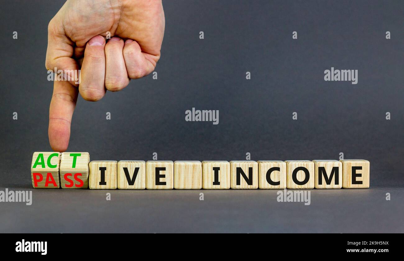 Passive or active income symbol. Businessman turns wooden cubes and ...