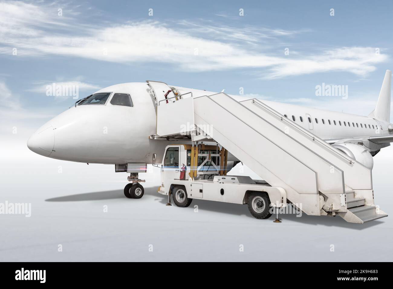 White passenger jet plane with an aircraft steps isolated on bright ...