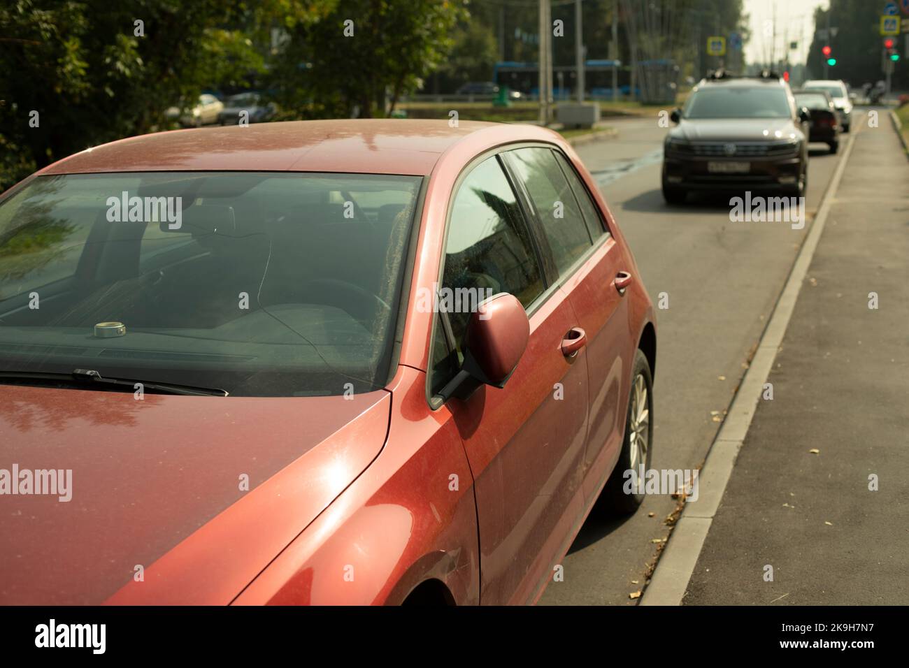 Red car in parking lot. Car is on side of road. Transport in city in ...