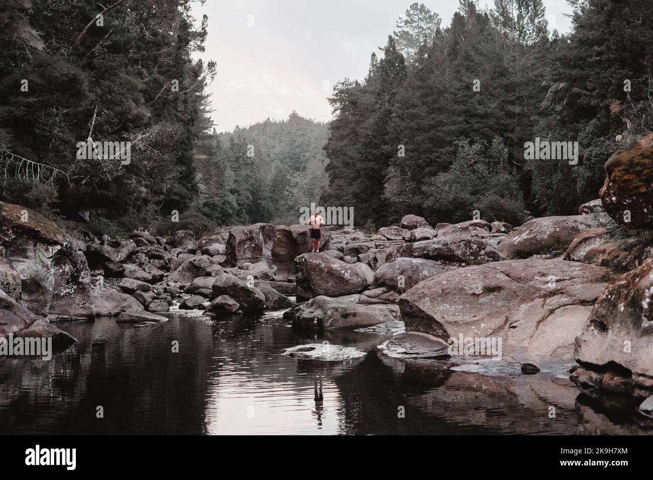 boy standing on the big rock looking at his camera screen Stock Photo ...