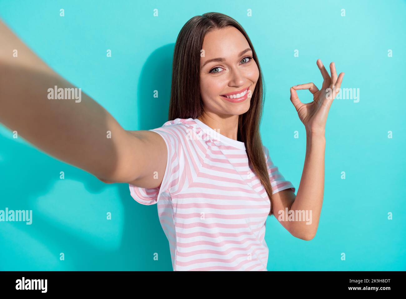 Portrait of positive funny woman with long hairdo dressed striped t ...