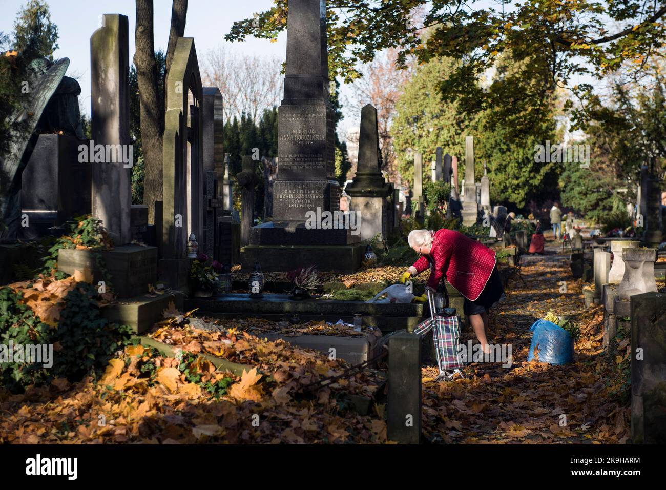 An elderly woman seen cleaning a grave at the historic Powazki Cemetery ...