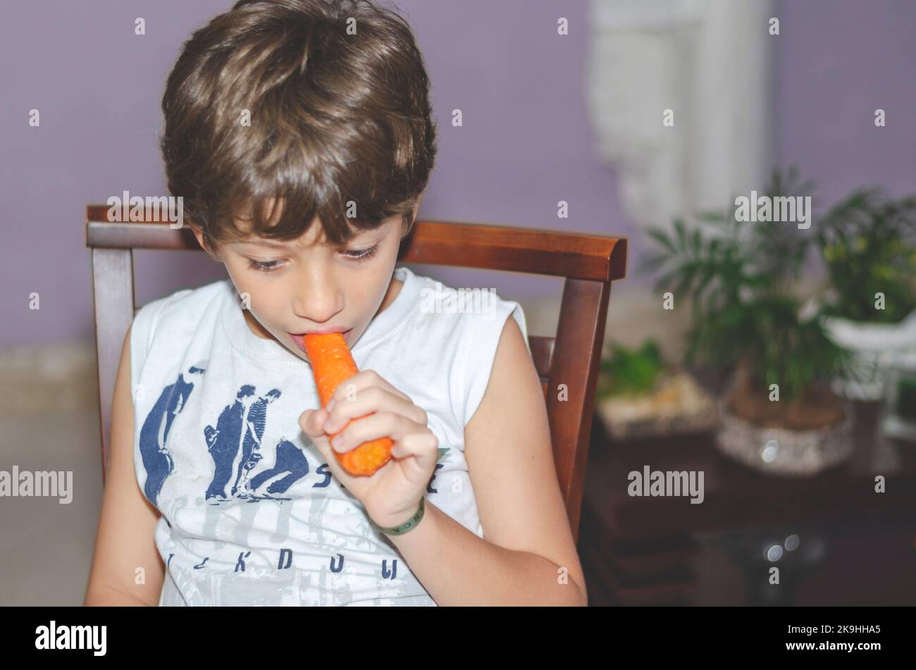 Happy little boy eating a fresh carrot and having fun. Healthy ...