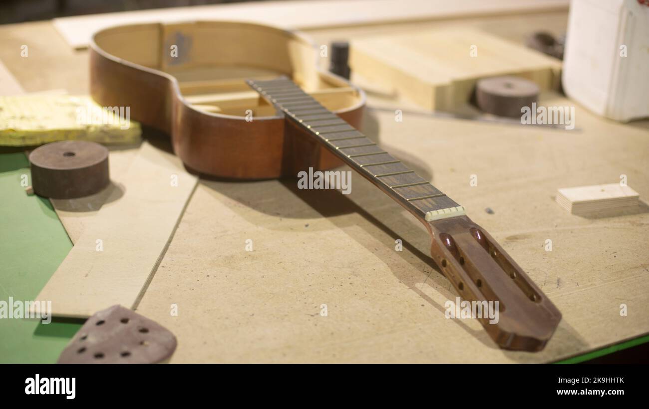 Guitar repair. Guitar in wood workshop. Tool bonding. Details of ...