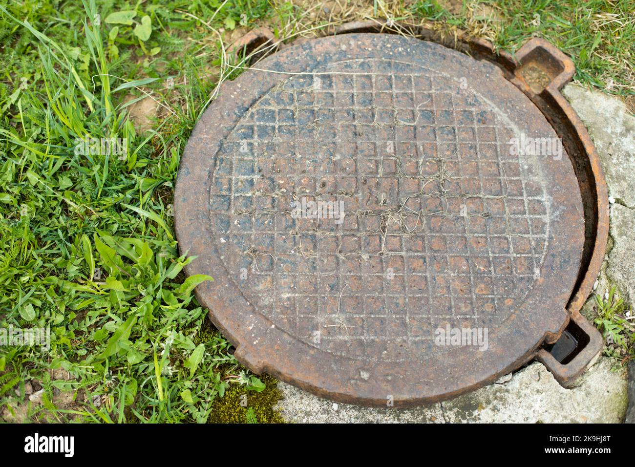 Steel manhole cover. Sewerage in city. Hatch in ground Stock Photo - Alamy