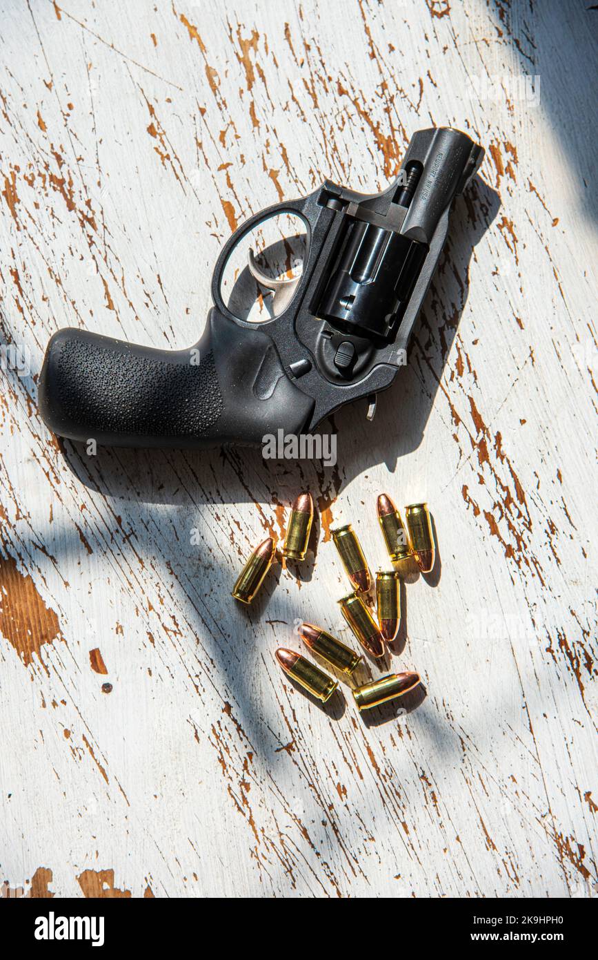 A black, Ruger, 9mm, snub-nosed revolver and a grouping of 9mm bullets ...