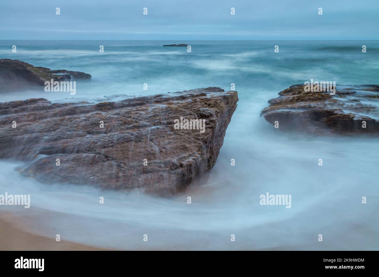A long exposure photograph captures the movement of ocean waves ...
