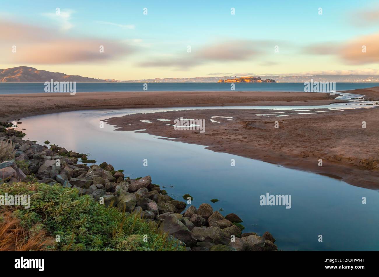 A tranquil scene unfolds with a winding inlet snaking through a sandy ...