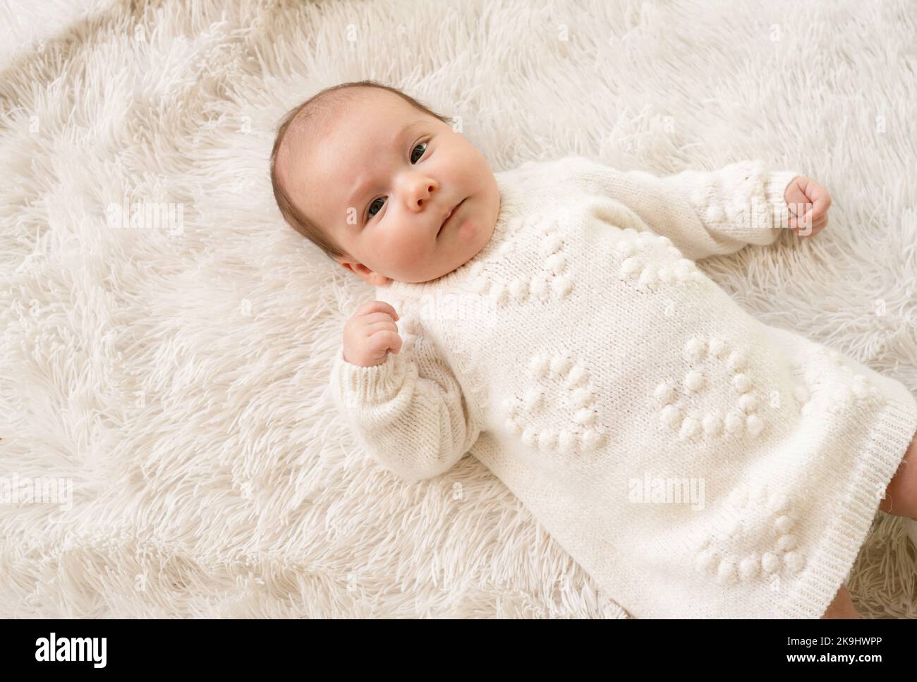 New born baby girl sleeping on texture blanket, lying on blanket, opened eyes, white dress Stock ...