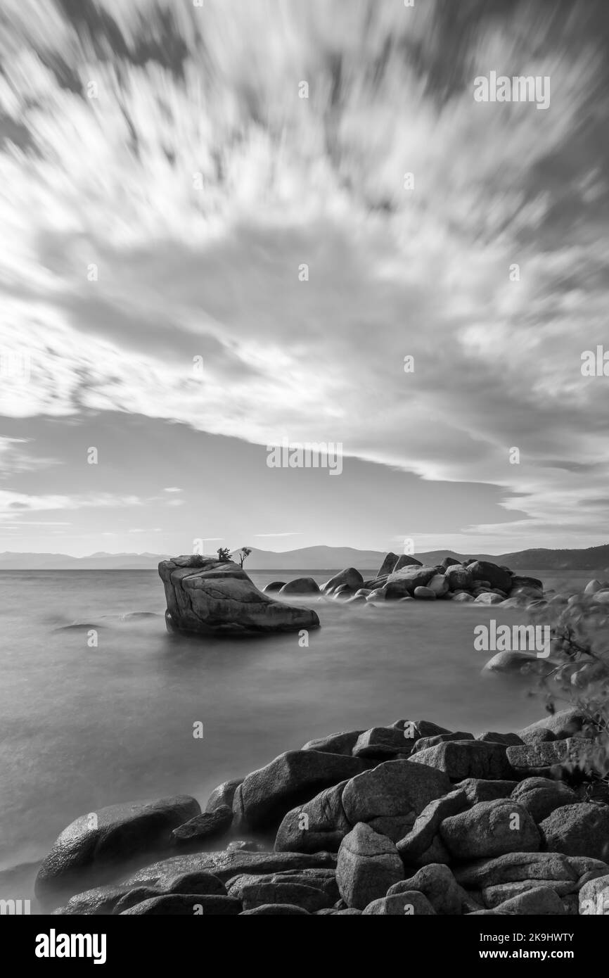 A black and white photograph captures a serene lakeshore scene at Lake ...